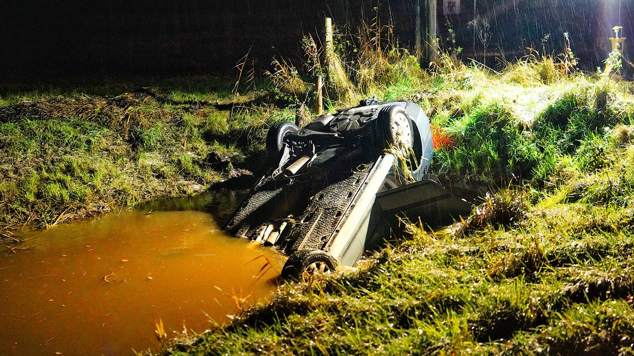 Auto belandt ondersteboven in sloot en drijft tientallen meters verder ...