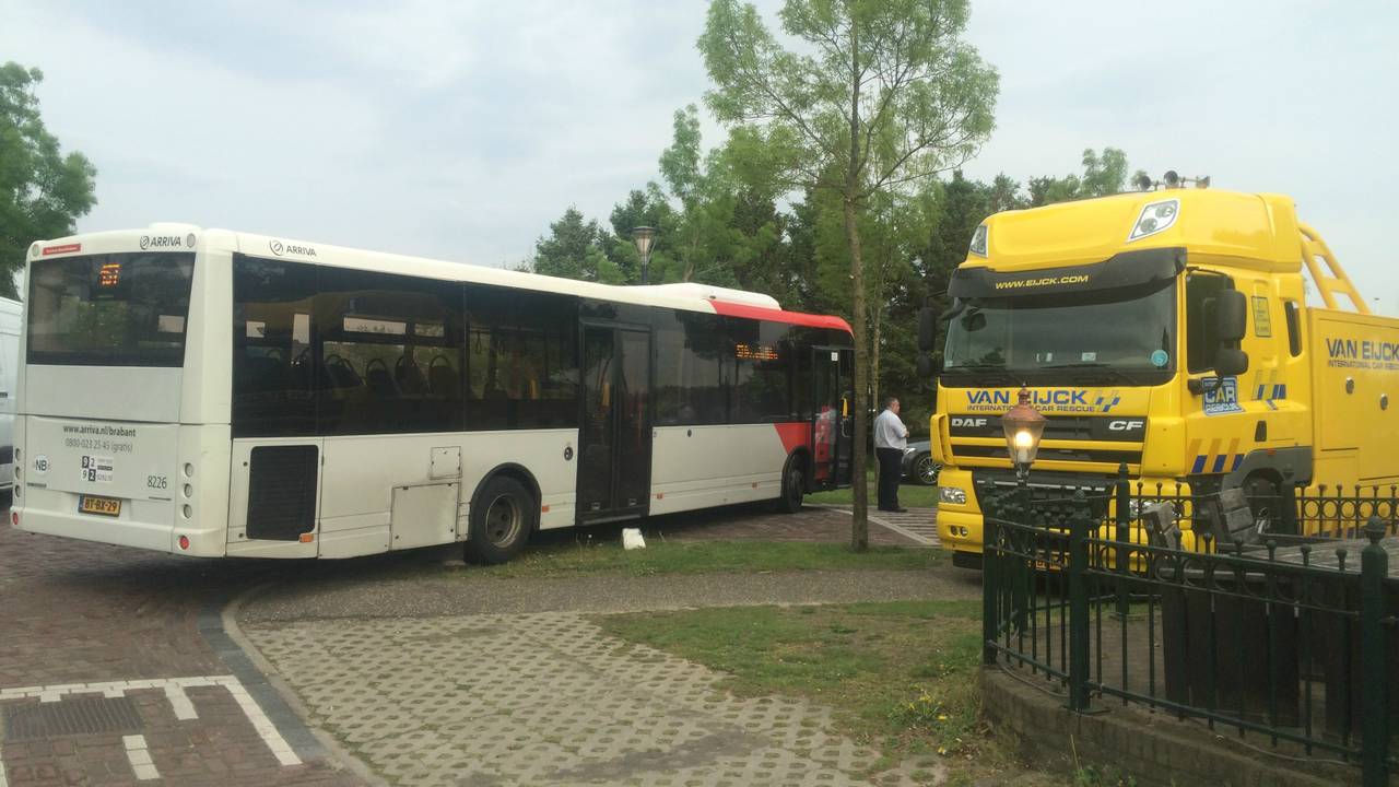 Bus rijdt verkeerd en komt vast te zitten op betonnen verkeersgeleider ...