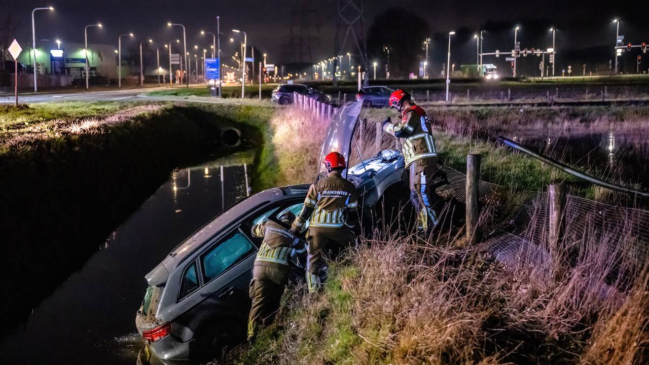 Auto mist bocht en crasht, ramt lantaarnpaal en belandt op rand van ...